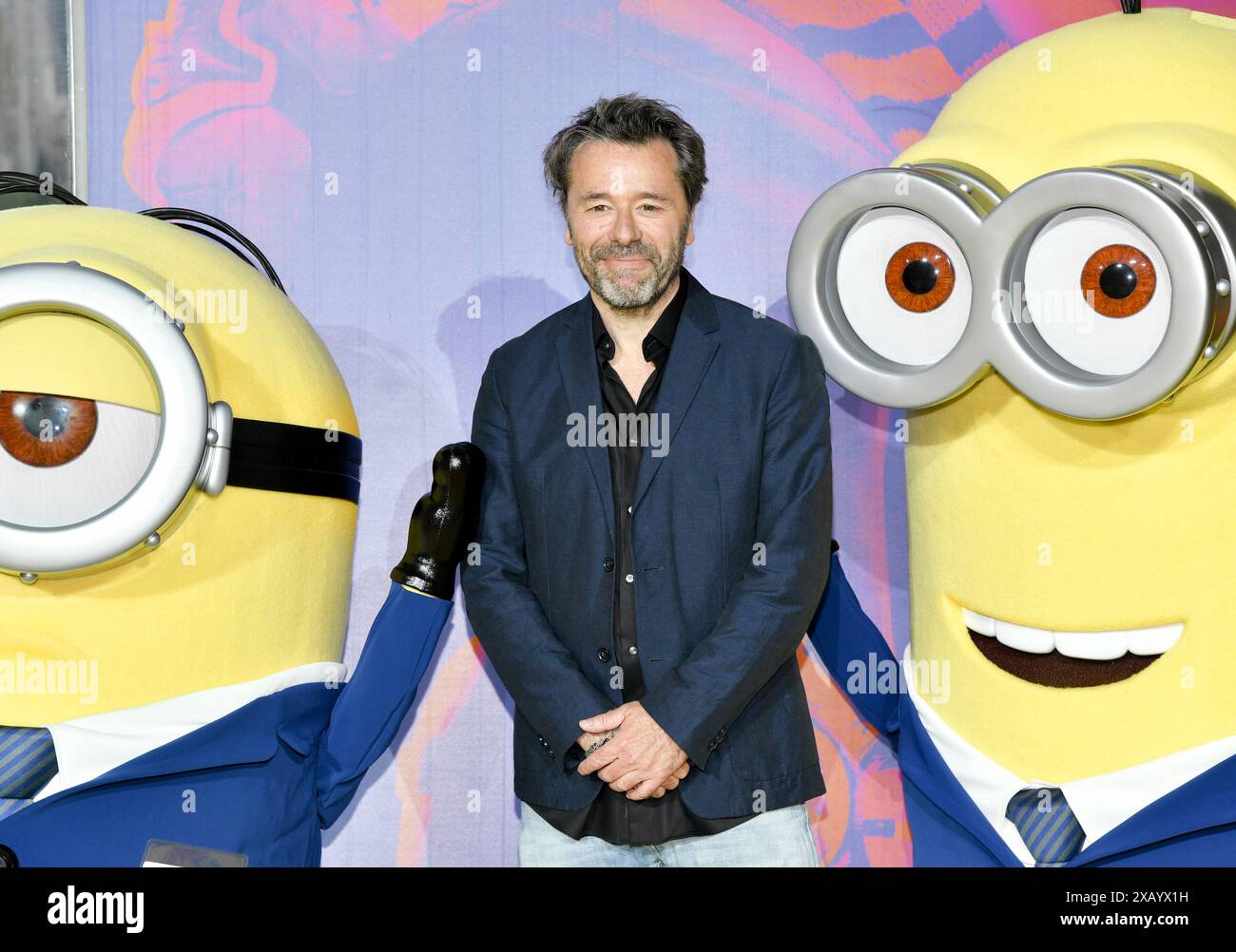 Co-director Patrick Delage poses with Minion characters at the premiere ...