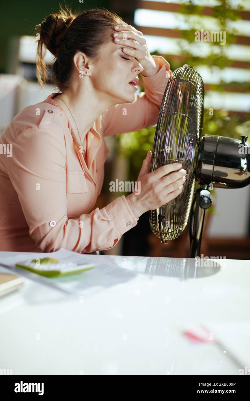 Sustainable workplace. modern female worker in modern green office with ...