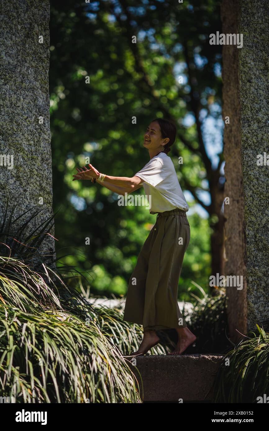 A young woman dances in the park, displaying her choreography and fluid ...