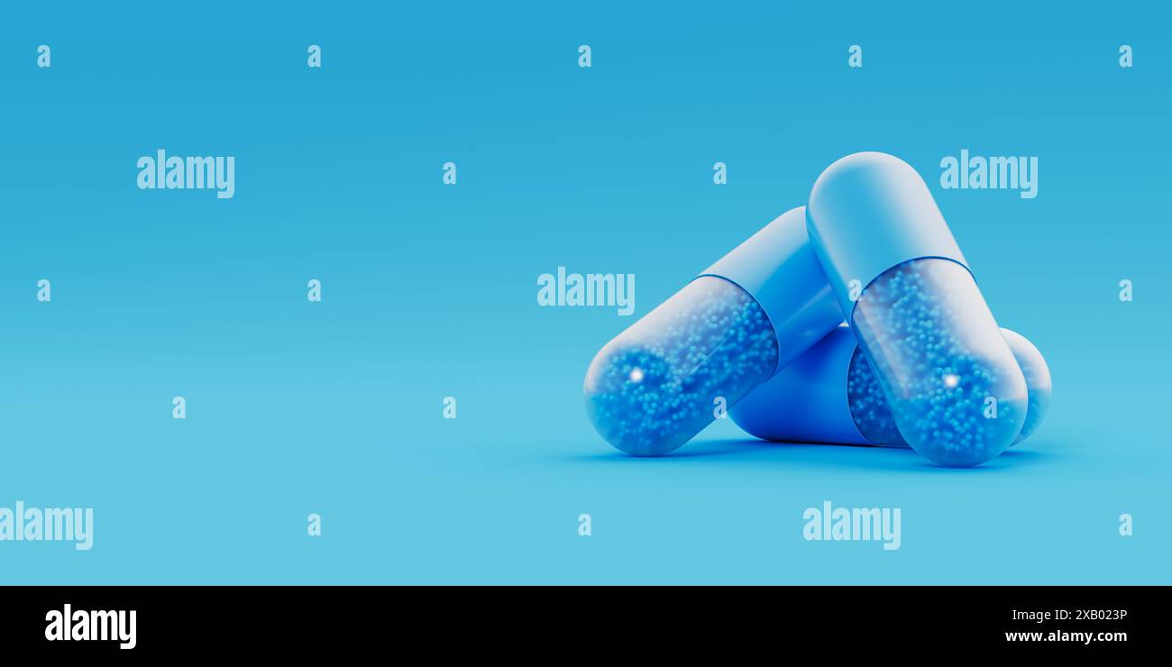 Three blue transparent capsules, pills with blue granules inside lay on ...