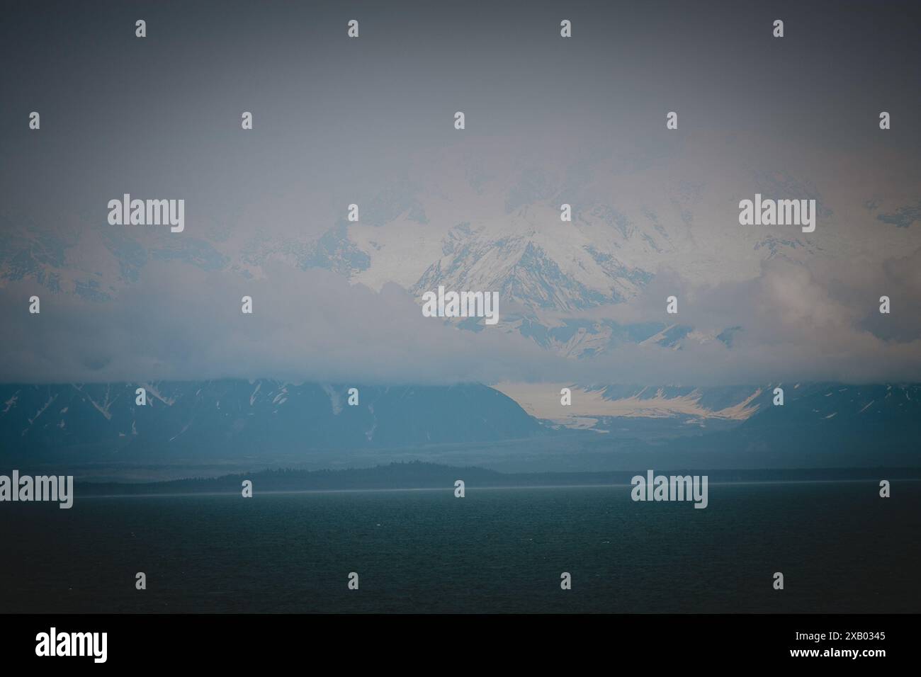 A breathtaking view of an Alaskan mountain range shrouded in mist and ...
