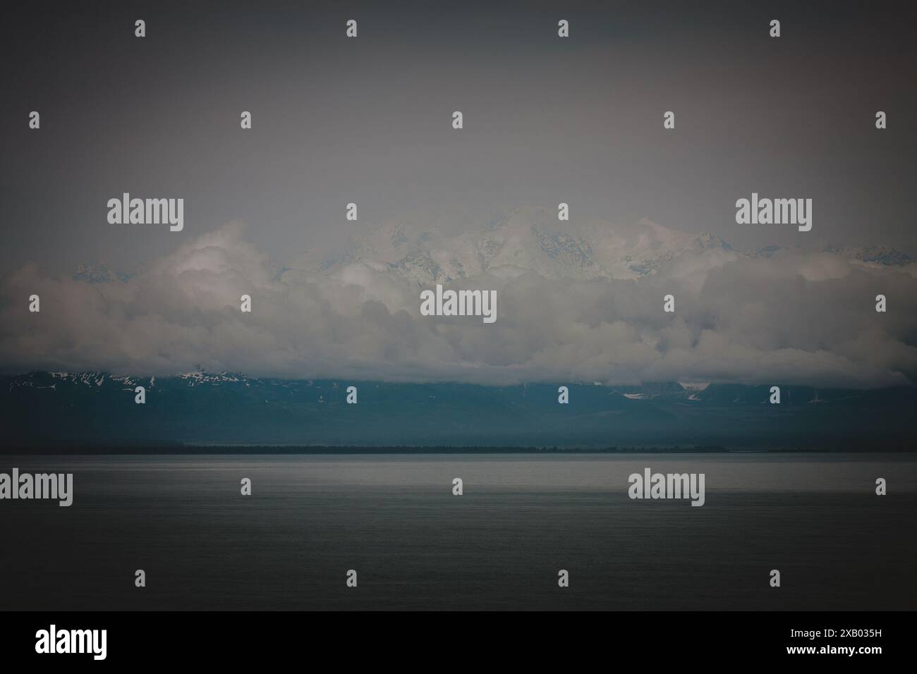 A breathtaking view of Alaskan snow-capped mountains partially obscured ...