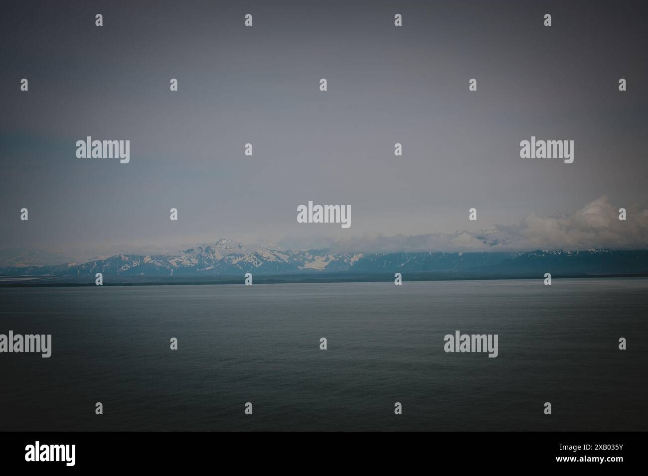 A breathtaking view of Alaskan snow-capped mountains partially obscured ...