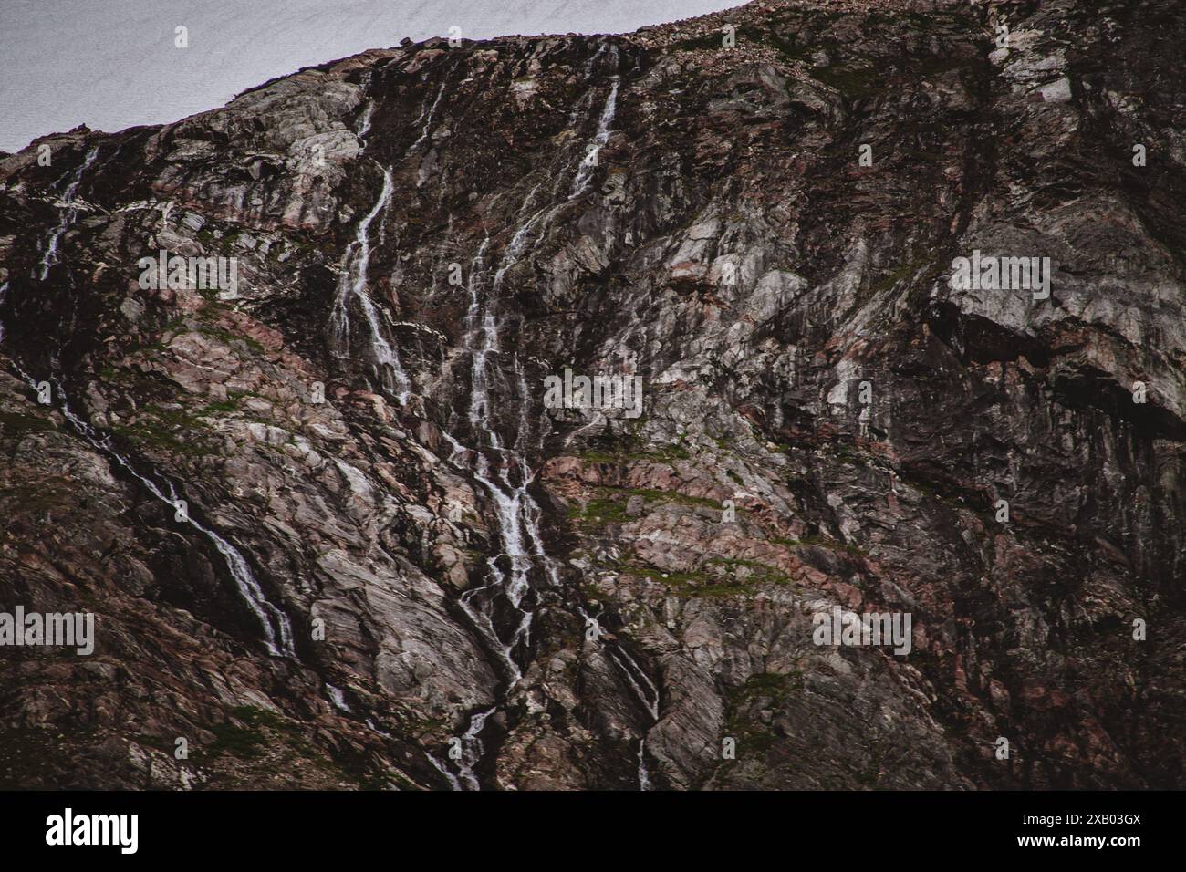 A breathtaking close-up of a waterfall streaming down the rugged cliffs ...