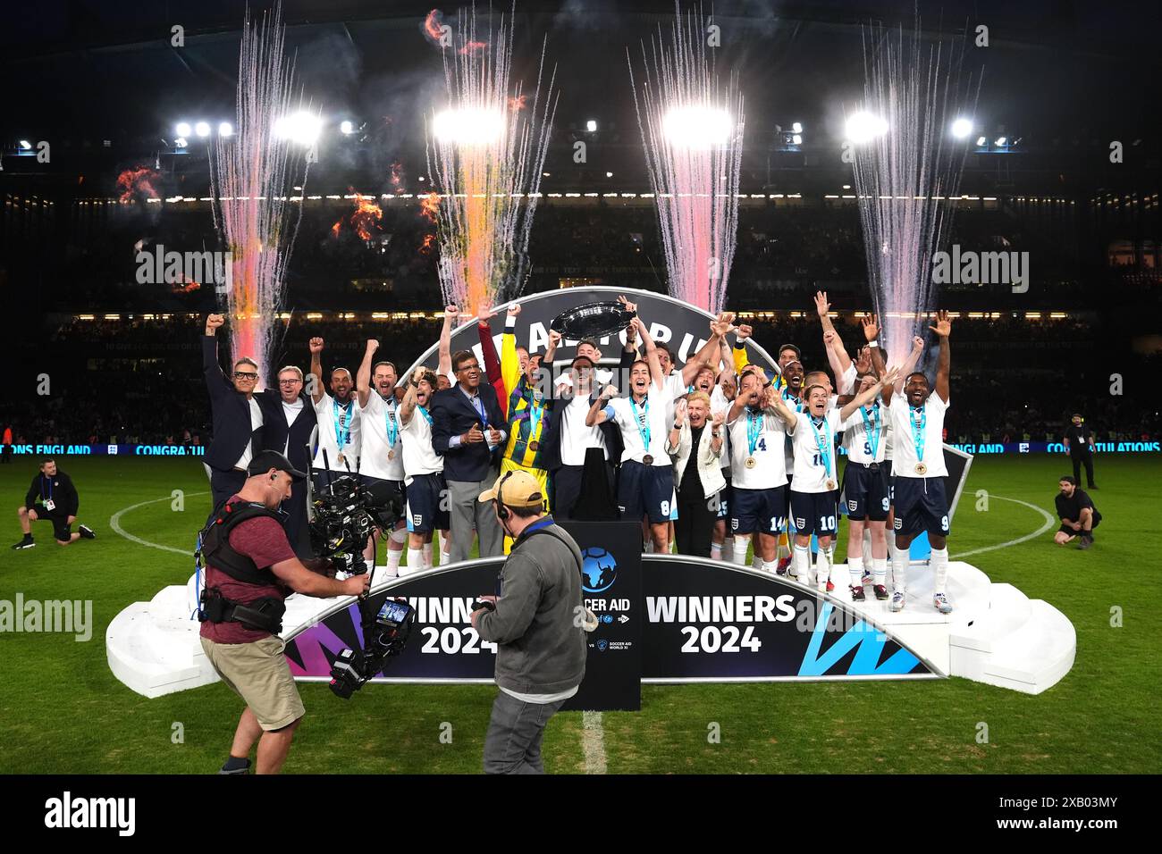 England players and coaches celebrate with the trophy following victory ...