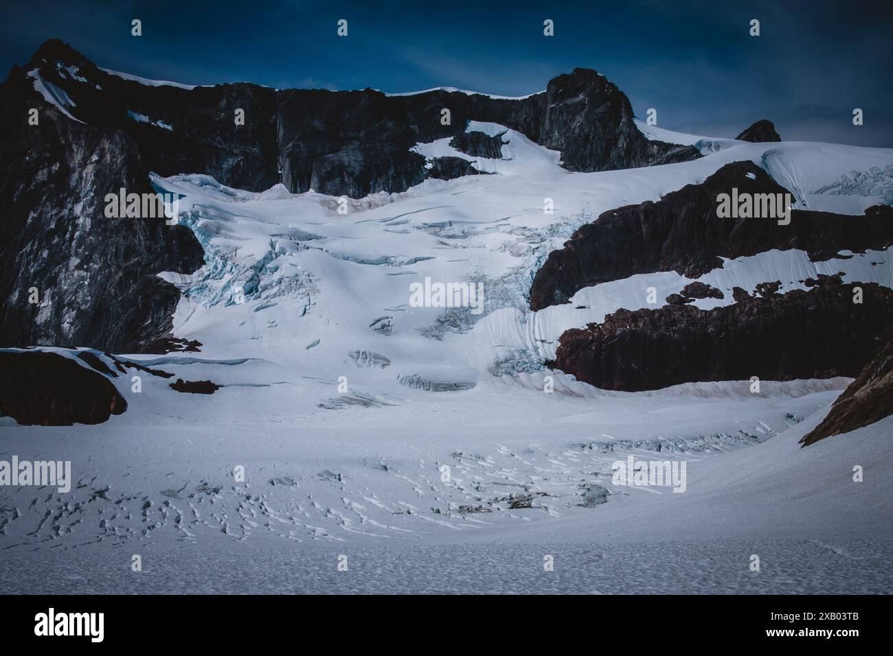 A stunning view of an Alaskan glacier with snow-covered peaks and ...