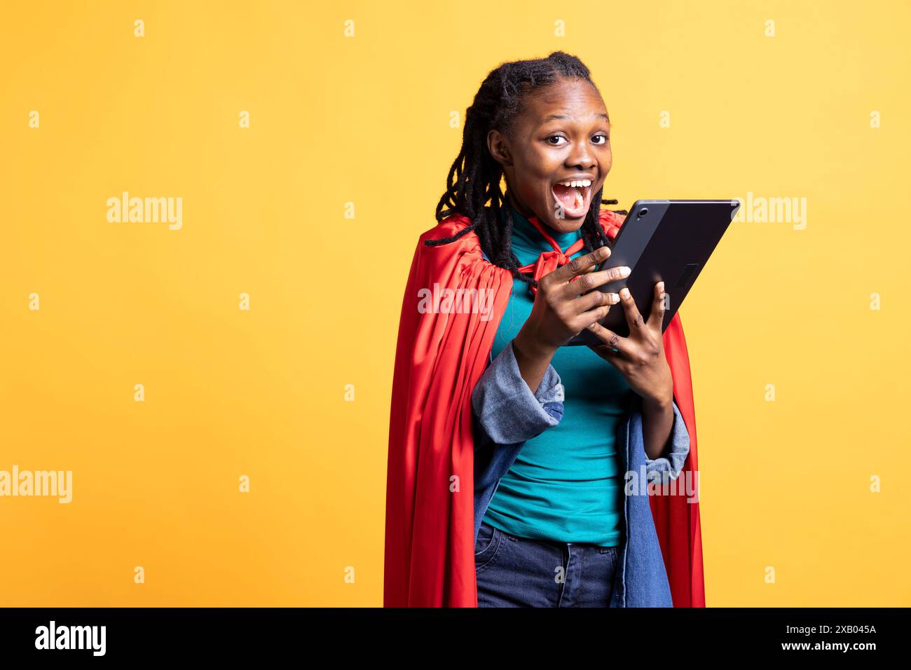 Portrait of ecstatic african american girl portraying superhero ...
