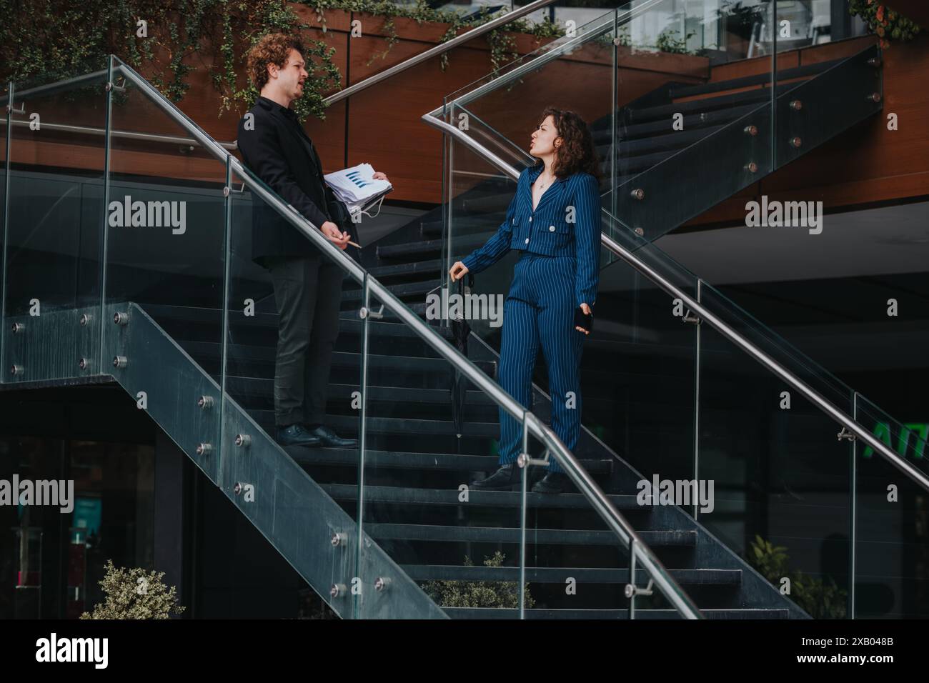 Businesspeople having a conversation on a modern office staircase Stock ...