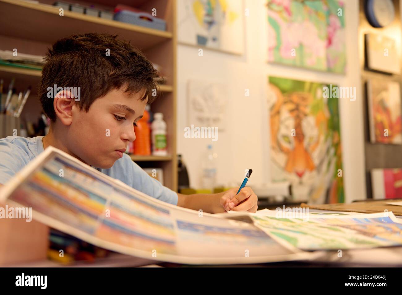 Kids have art class, drawing, painting with teacher in workshop. Young boy intensely focused on ...