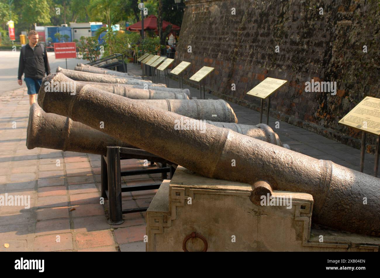 Man walking pass old cannons at the base of the Flag Tower, Vietnam War, Vietnam Military ...