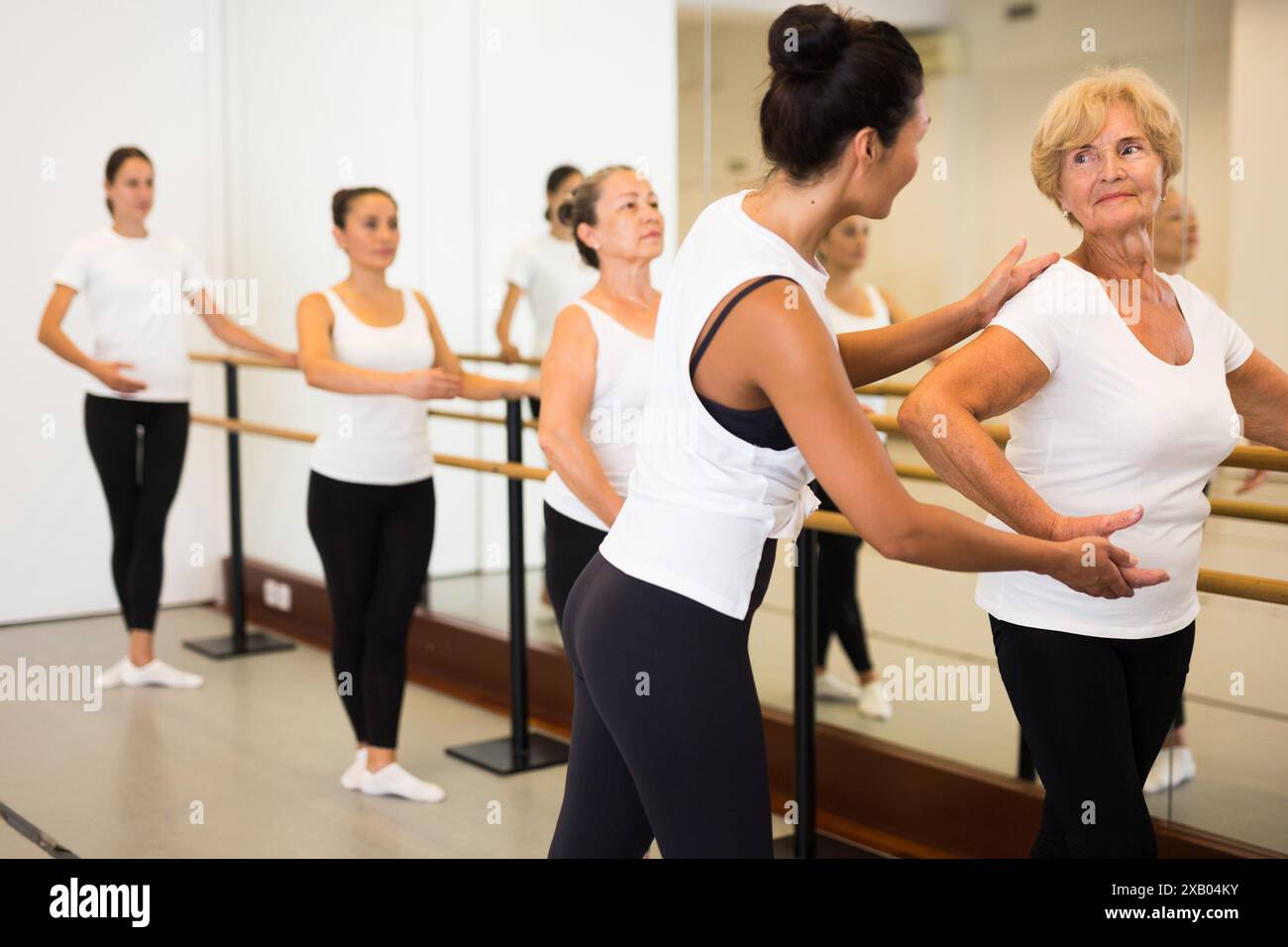 Female choreographer and group of multiracial dancers in dance school ...