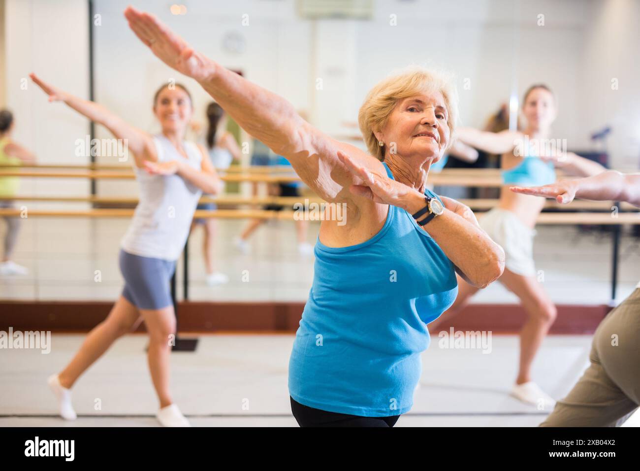 Portrait of mature woman practicing ballet dance moves during group ...
