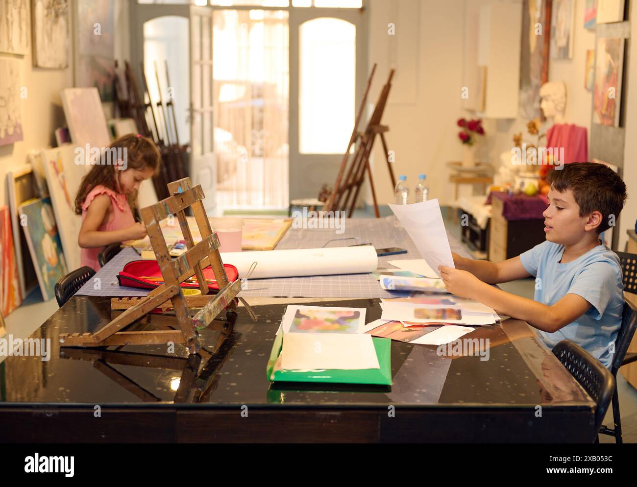 Children engaged in art class, focusing on drawing and painting ...