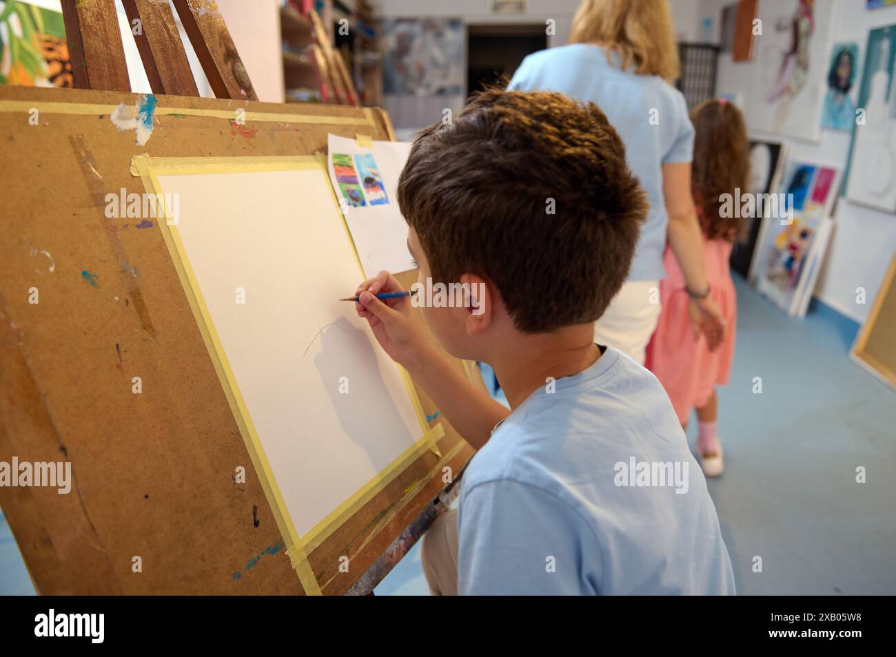 Kids have art class, drawing, painting with teacher in workshop ...