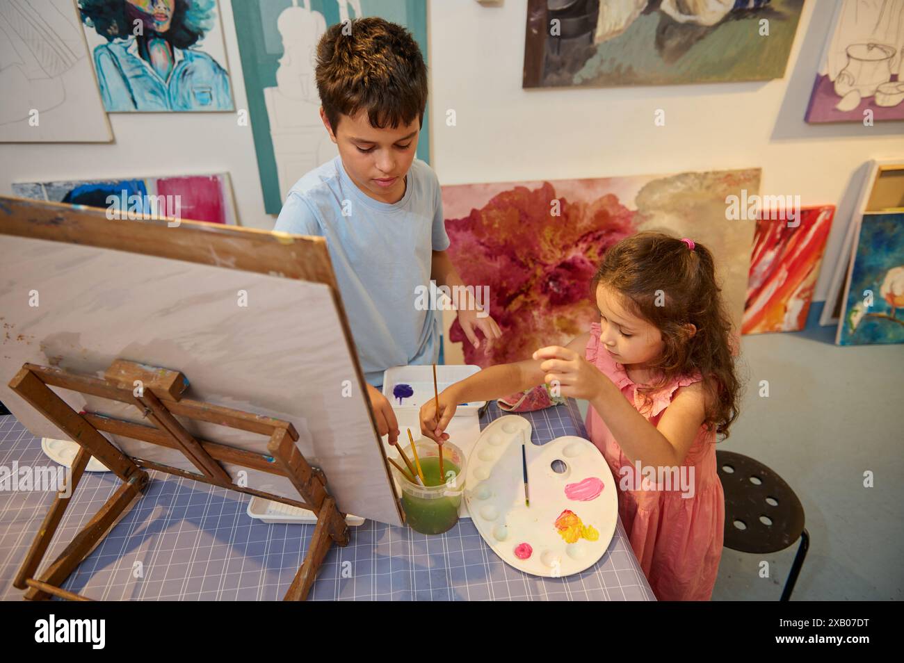 Kids have art class, drawing, painting with teacher in workshop ...