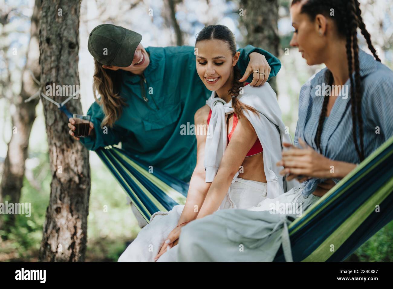 Group of young friends enjoying a relaxed day in nature on a hammock ...
