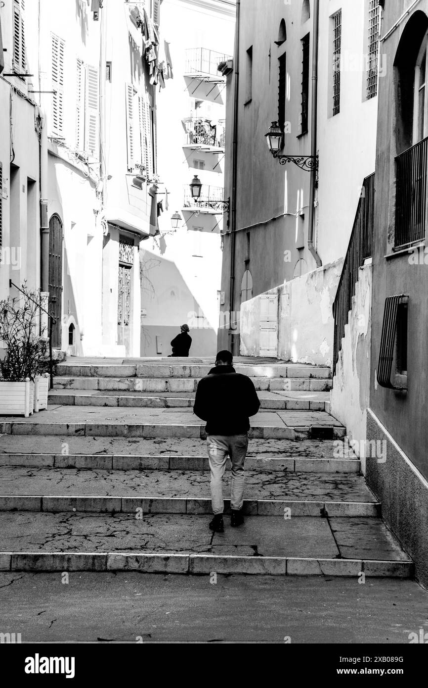 black and white image, old town, Nice France, one man walking away up ...