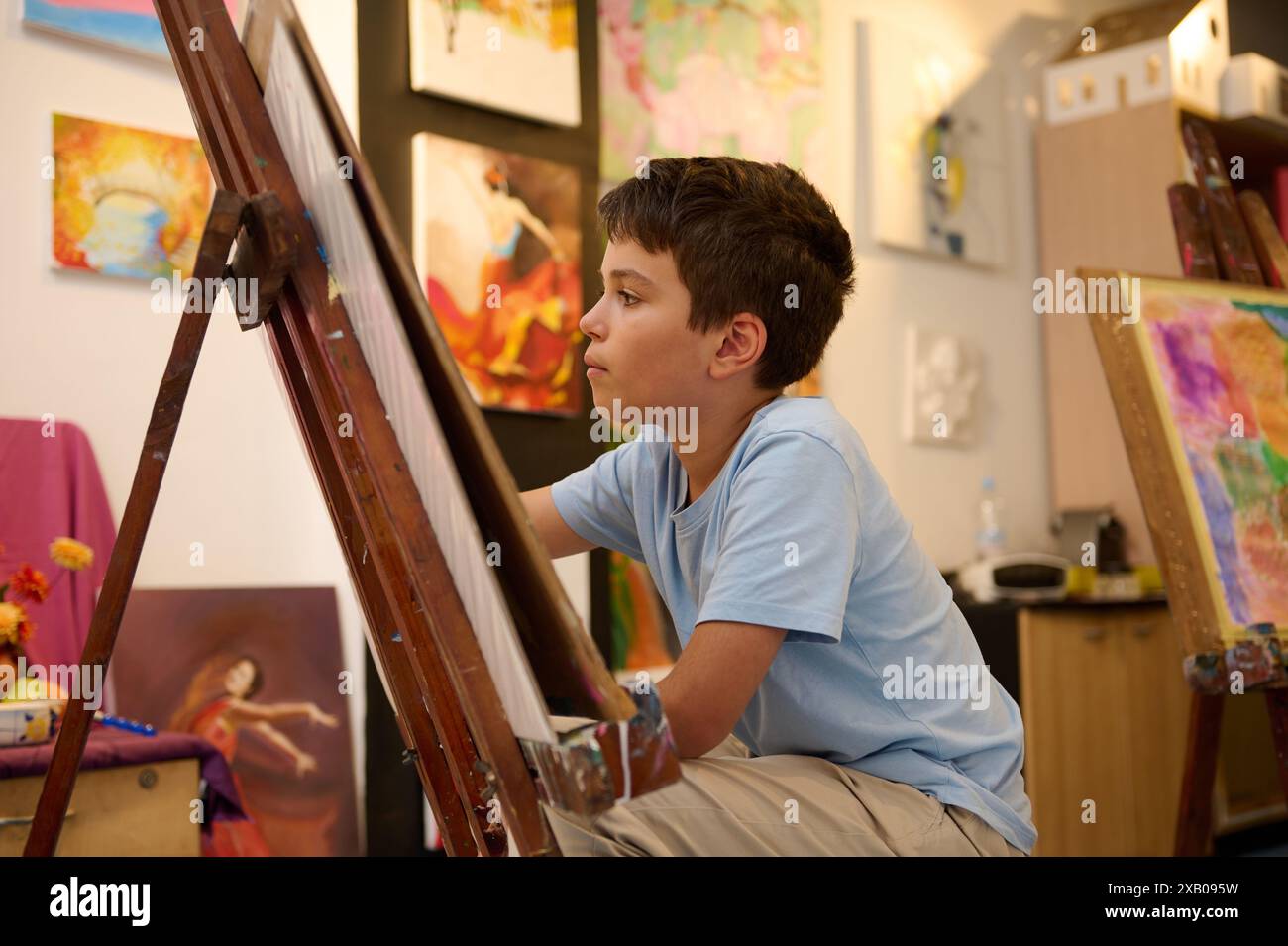 Young boy painting in art class, focused on his artwork in a creative workshop Stock Photo - Alamy