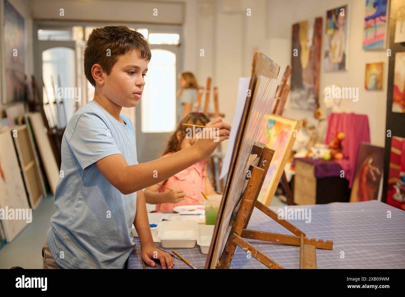 Children participating in an art class, drawing and painting with ...