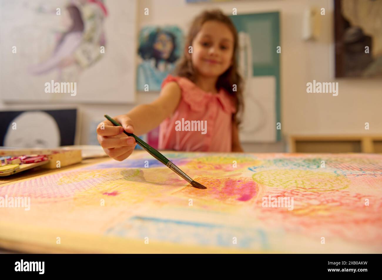 Girl enjoying painting during art class. Young artist creating colorful ...