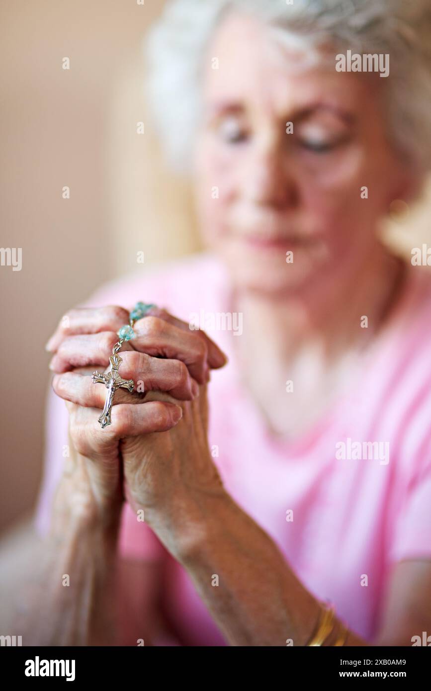 Senior woman, praying and catholic in home with rosary for hail mary ...