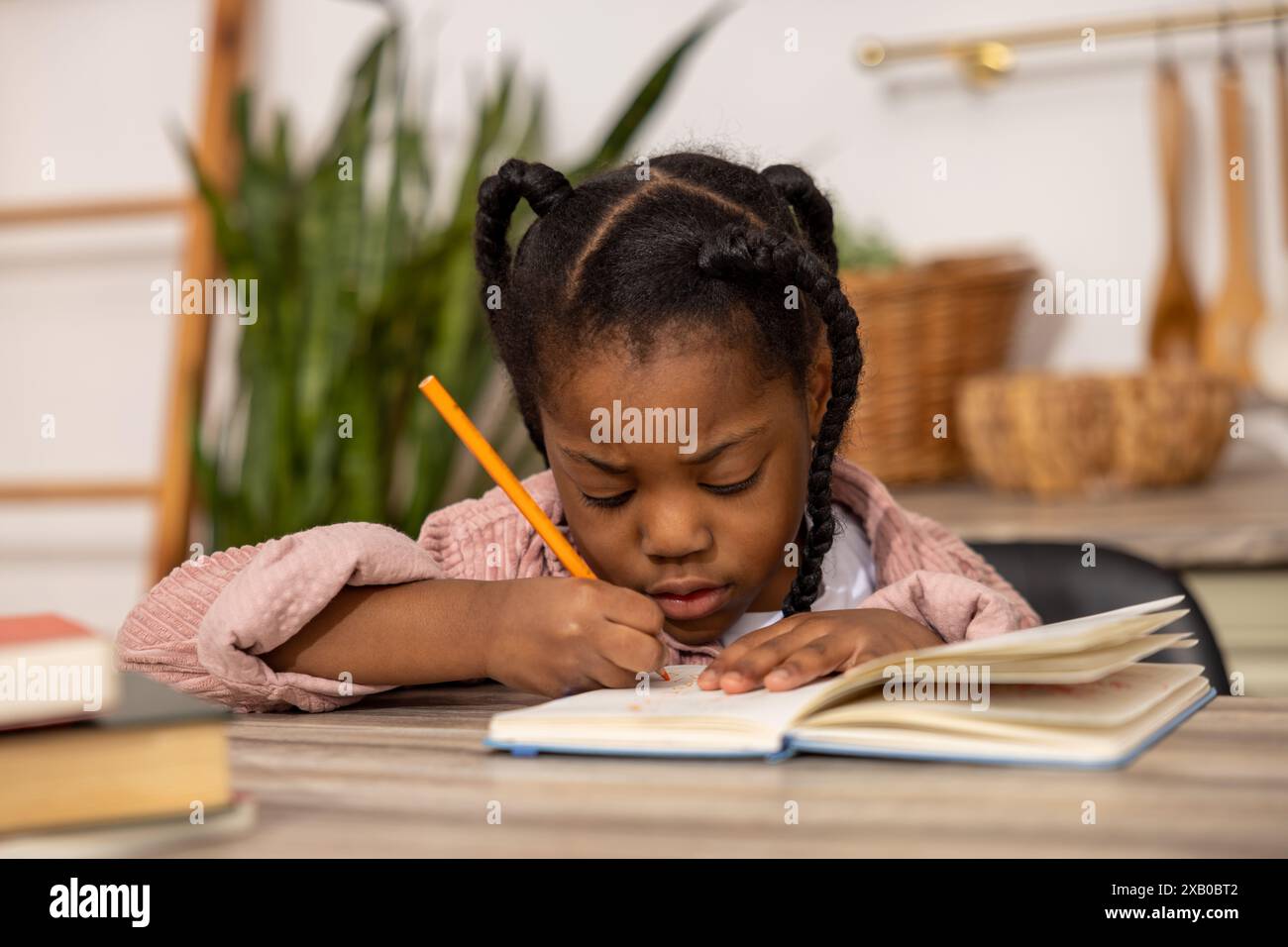 Tired multicultural girl writing in her exercise book with sad ...