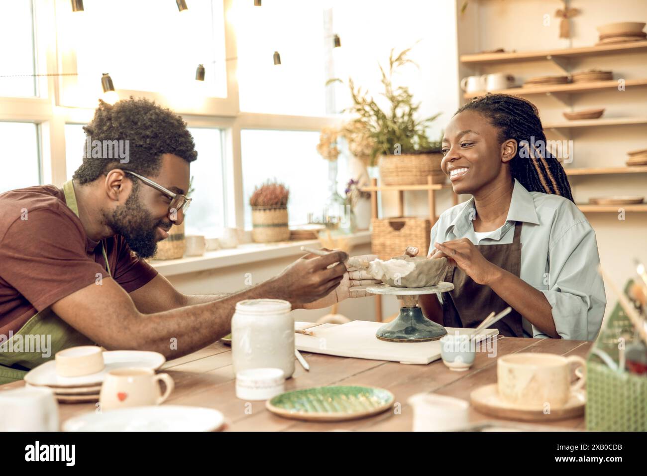 Two people working with pottery and looking involved Stock Photo - Alamy