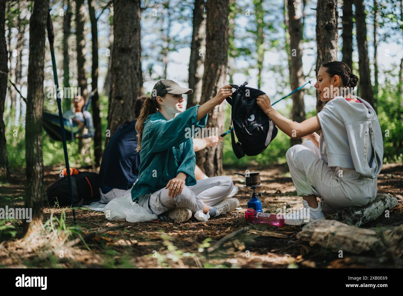 Group of friends enjoying a camping trip in the forest, sharing ...