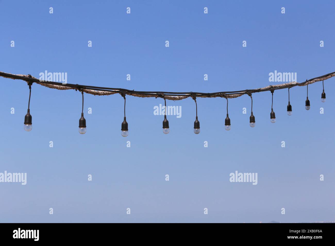 Bunch line of light bulbs that are disabled on blue sky background and ...