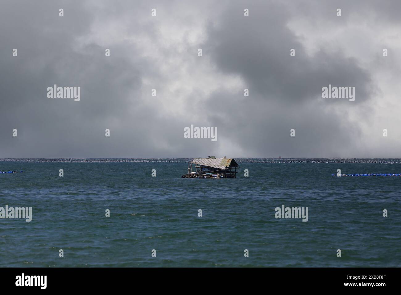 fisherman's floating raft in the middle of the sea on a rainy day ...