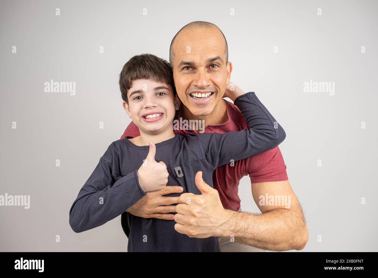Father and son hugging and smiling looking at the camera. Photos in studio 2 Stock Photo - Alamy