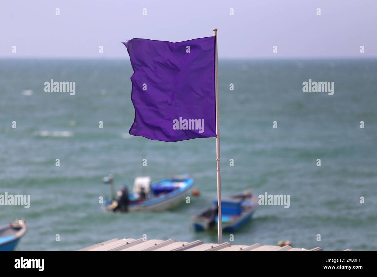 Empty Purple flag on the roof was waving with the wind from the sea ...