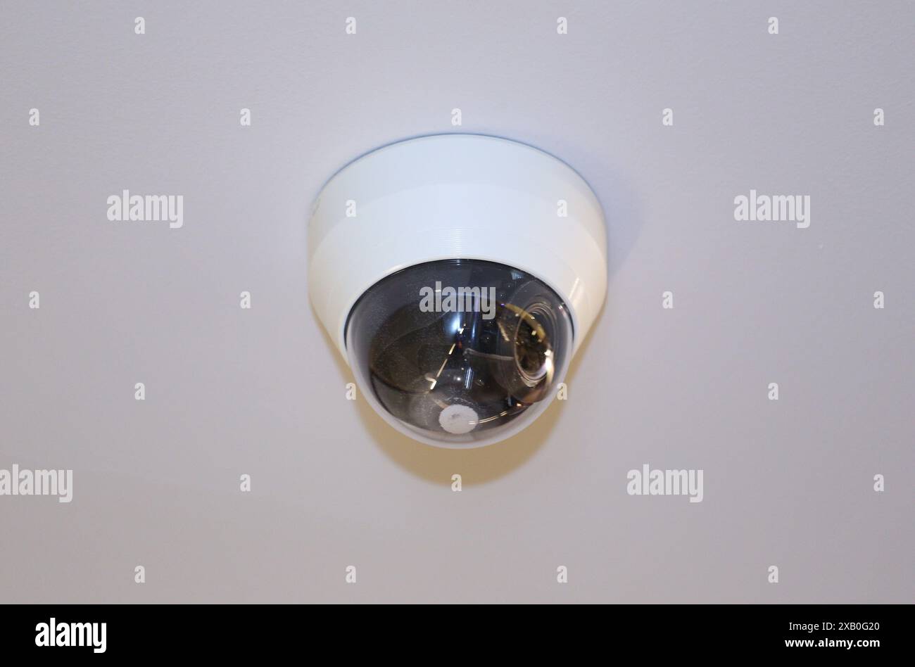 A dome-shaped CCTV camera mounted under the ceiling of the meeting room ...