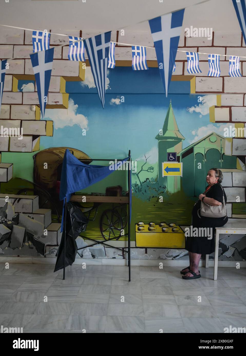 Athens, Greece. 9 June 2024. A voter stands next to a voting booth at a ...