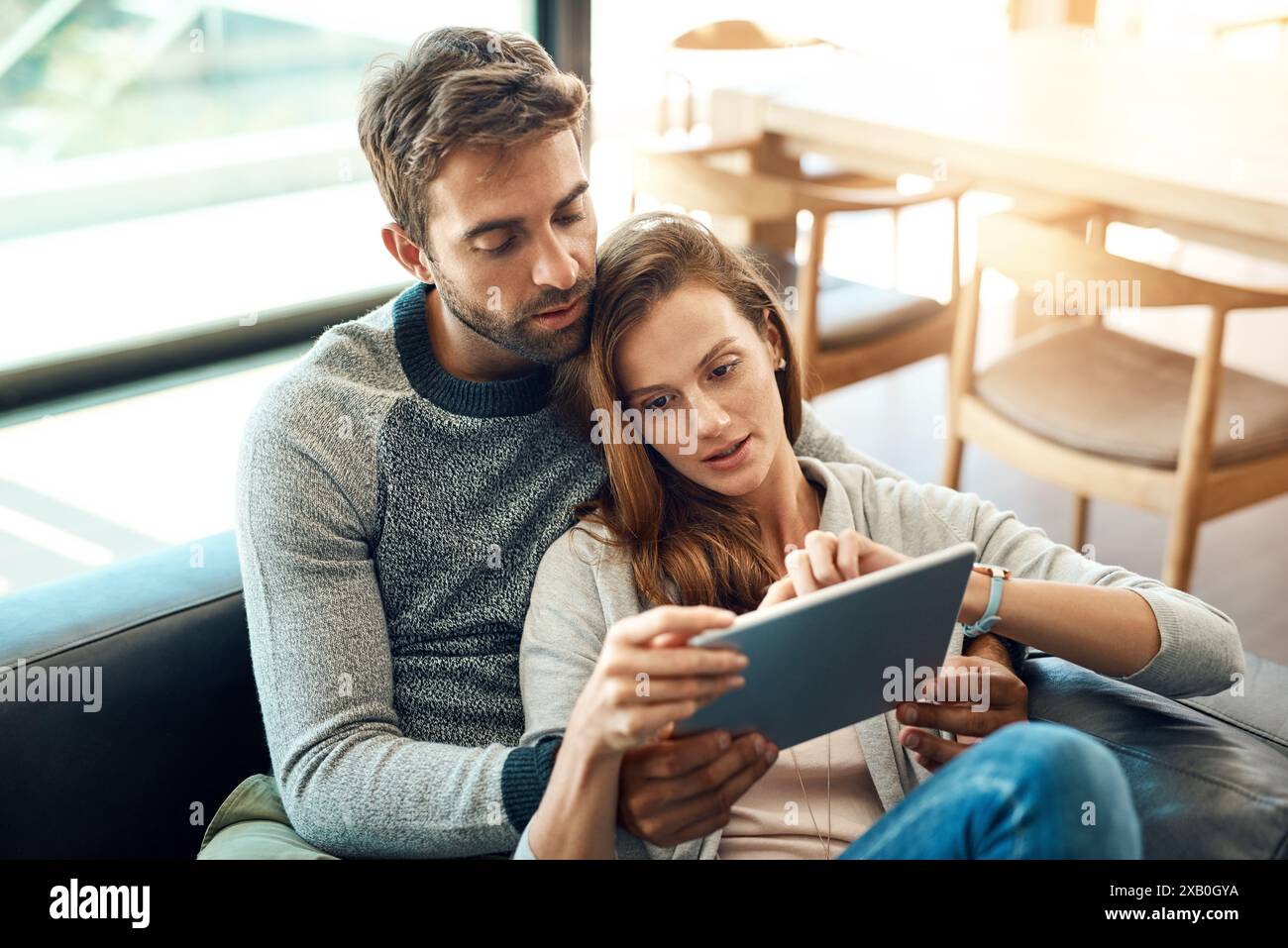 Hug, couple and tablet on sofa for web app, movie selection or ...