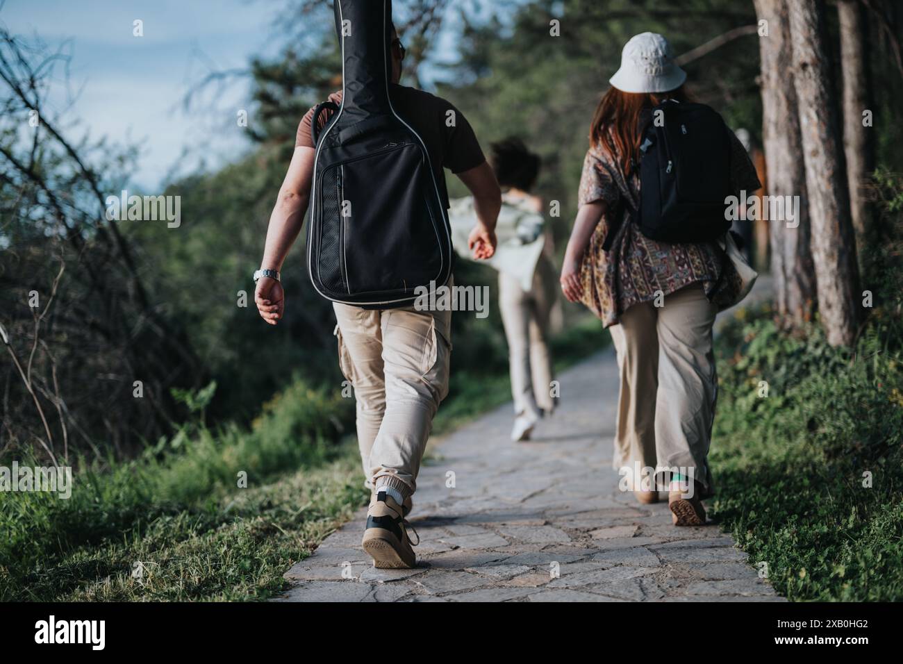Group of friends with backpacks strolling together on a scenic forest path during a peaceful ...