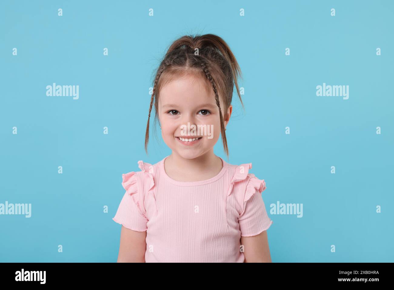 Portrait of cute little girl on light blue background Stock Photo - Alamy
