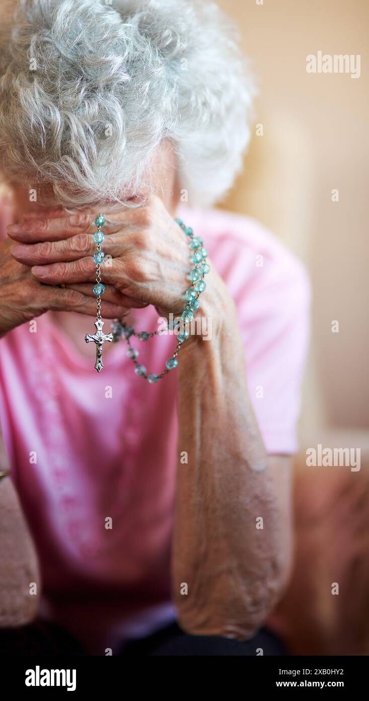 Senior woman, catholic and praying in home with rosary for hail mary ...
