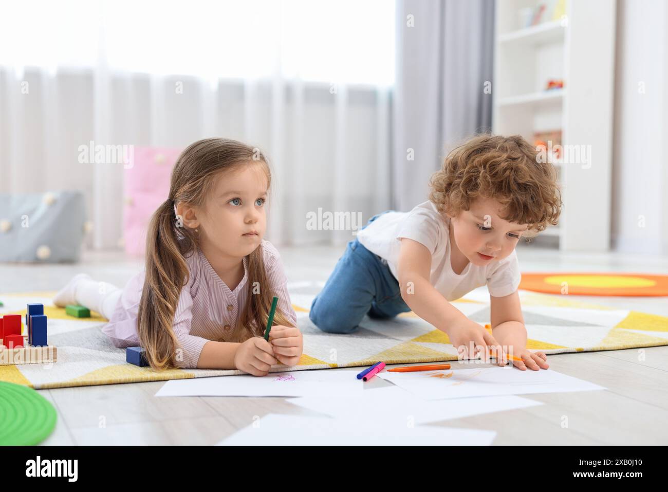 Cute little children drawing on floor in kindergarten Stock Photo - Alamy