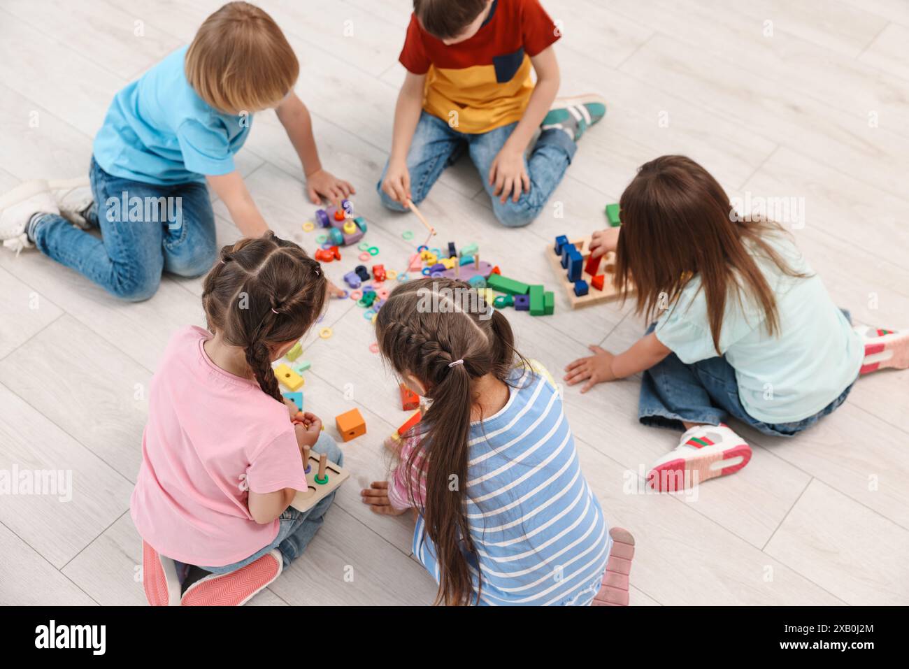 Group of children playing together on floor indoors Stock Photo - Alamy