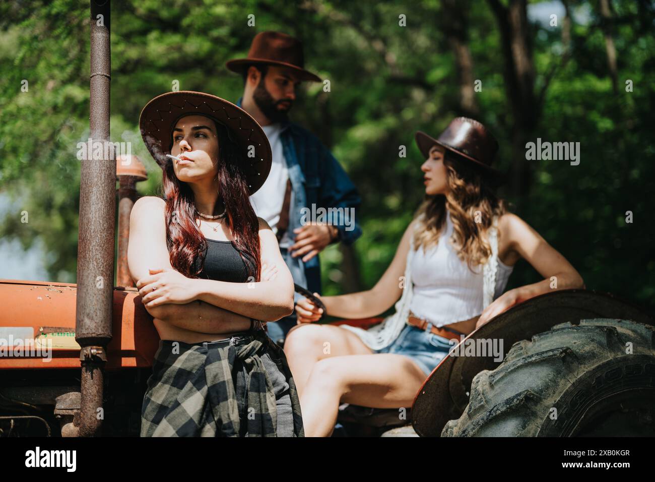 Group of friends wearing cowboy hats posing outdoors in a rural setting ...
