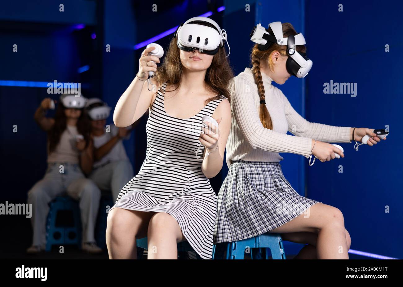 Female friends playing pair versus pair virtual reality game Stock ...