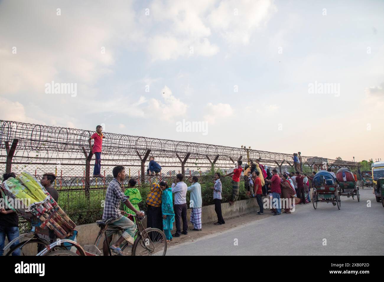 Curious people crowd to watch the aircraft landing outside the security ...