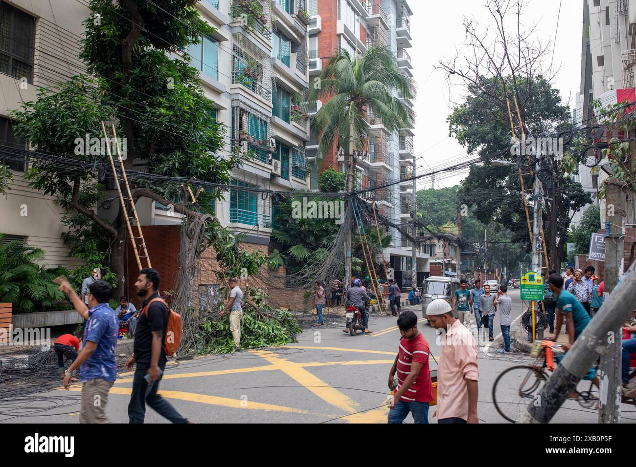 Workers repairing overhead internet cables damaged by a storm in Dhaka ...