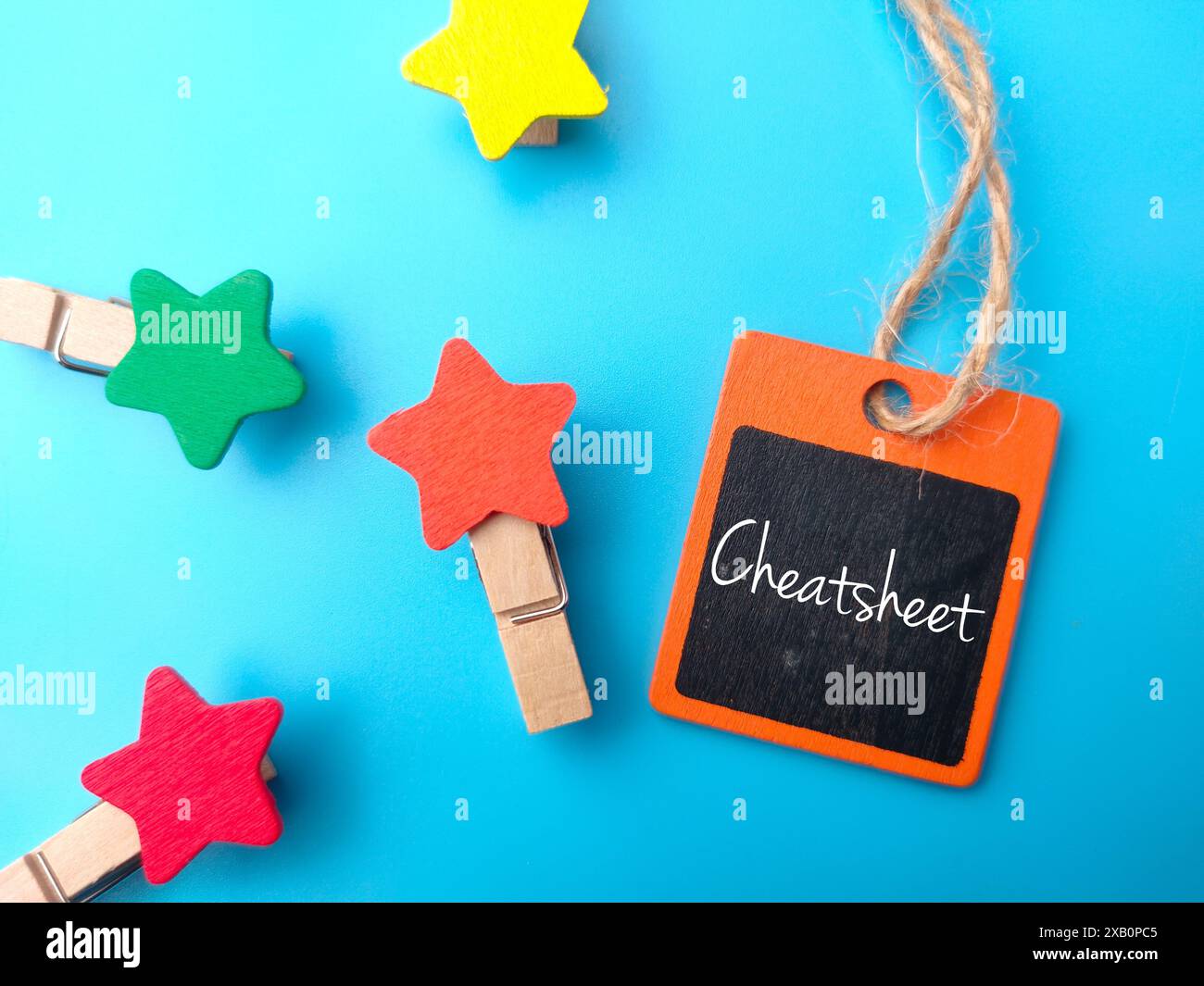 Colored wooden tag and wooden clips with text Cheatsheet on blue ...