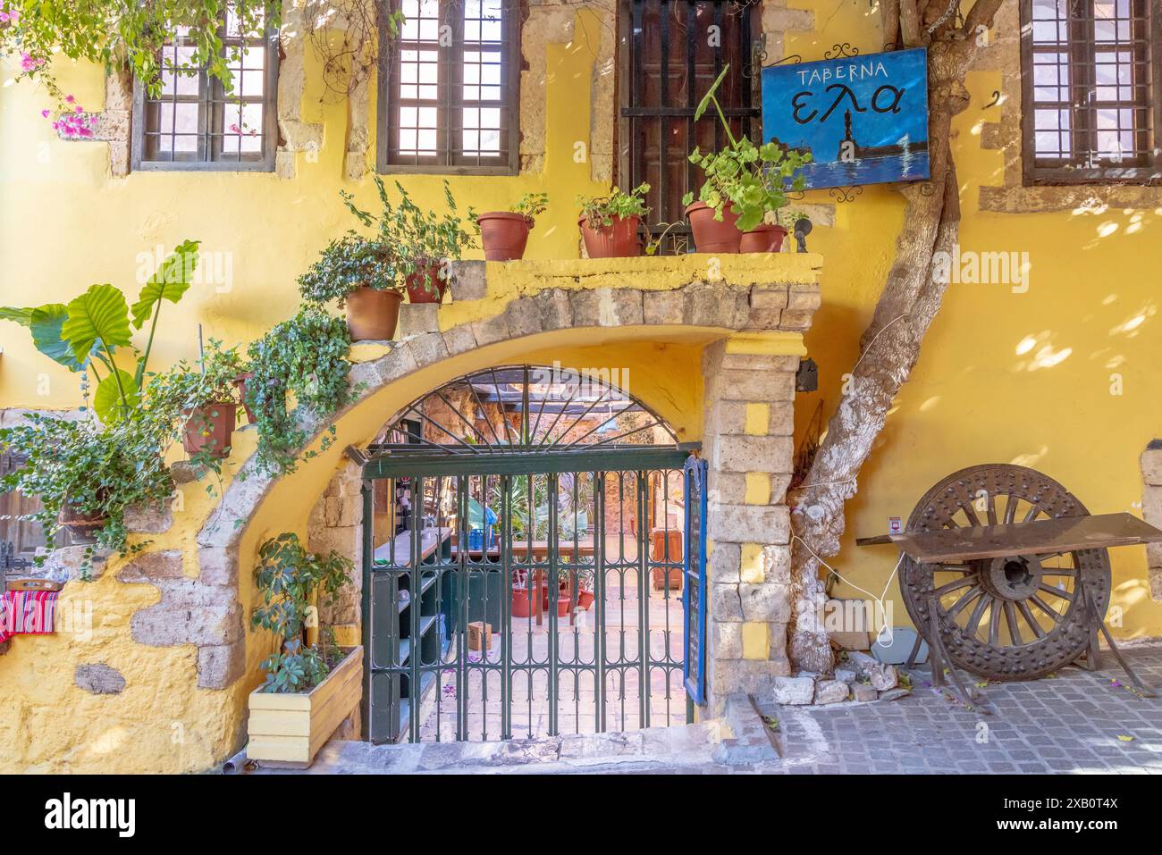 Europe, Greece, Crete, Chania, Old Town. Cafe behind barred gate in ...