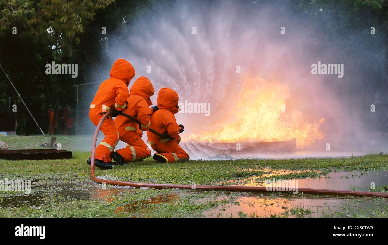Firefighter fighting with flame using fire hose chemical water foam ...
