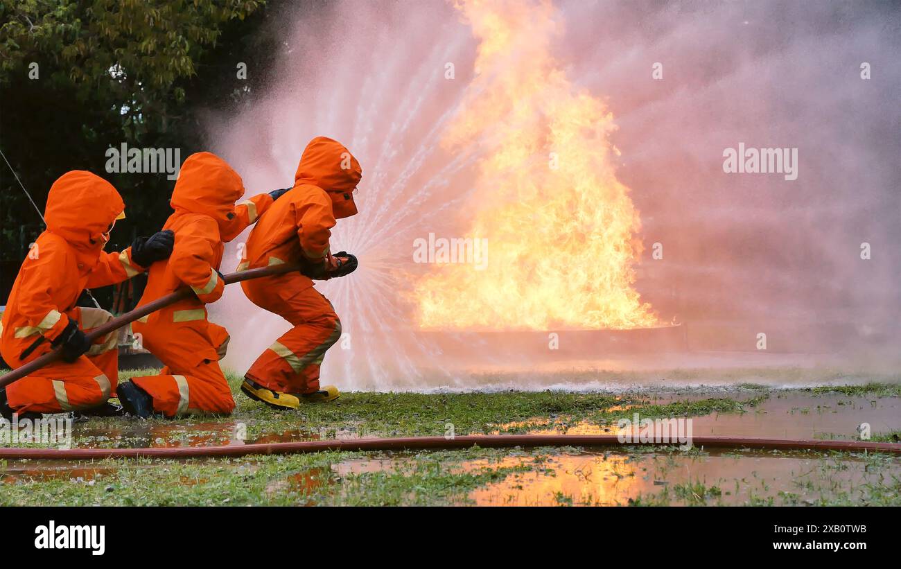 Firefighter fighting with flame using fire hose chemical water foam ...