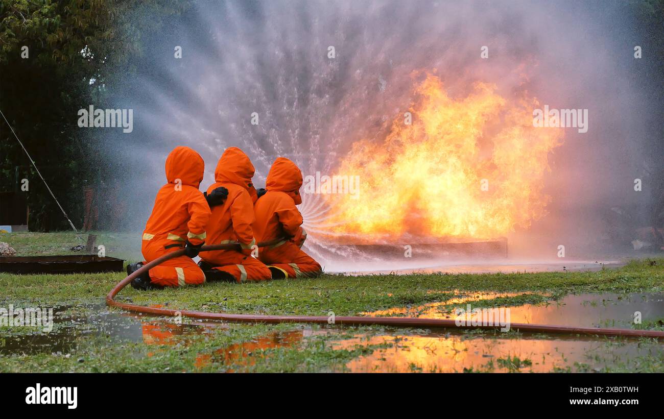 Firefighter fighting with flame using fire hose chemical water foam ...