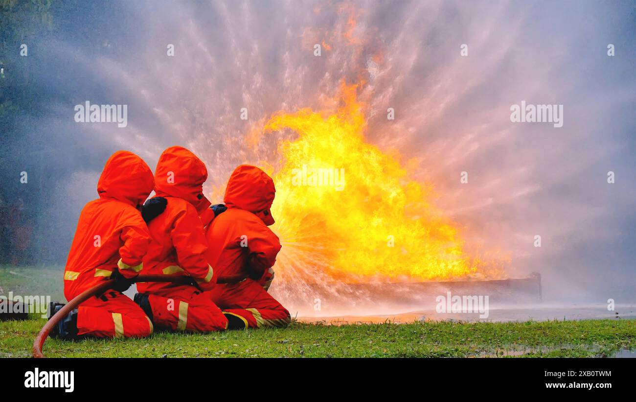 Firefighter fighting with flame using fire hose chemical water foam ...